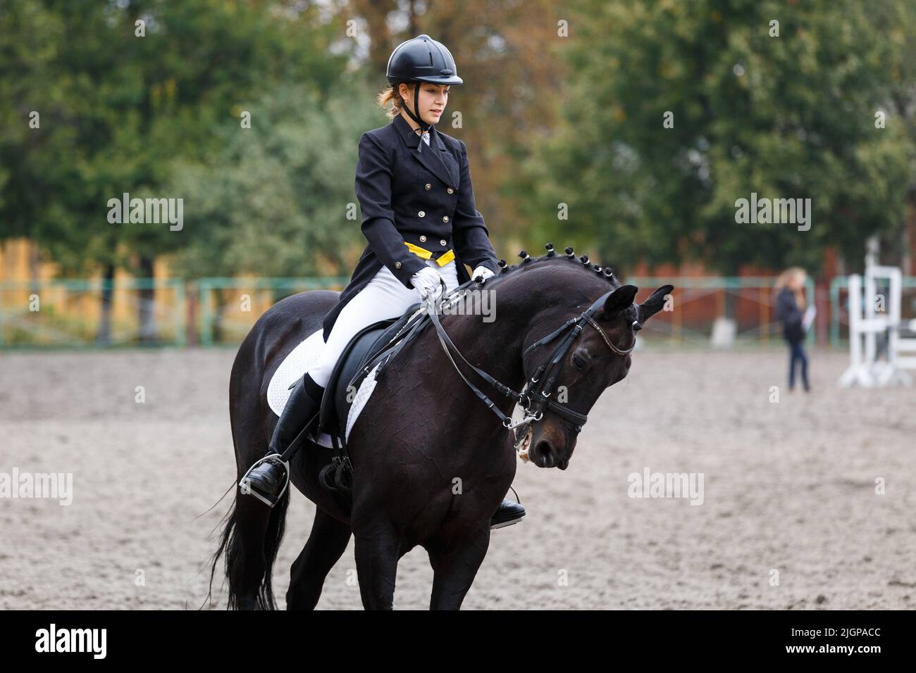 Young teenage girl riding raven horse on dressage equestrian event ...