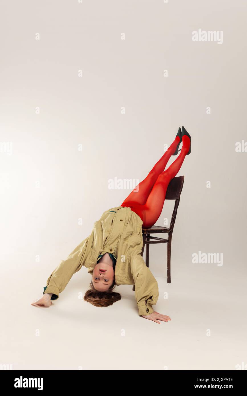 Portrait of young girl in red tights and stylish jacket posing, falling ...