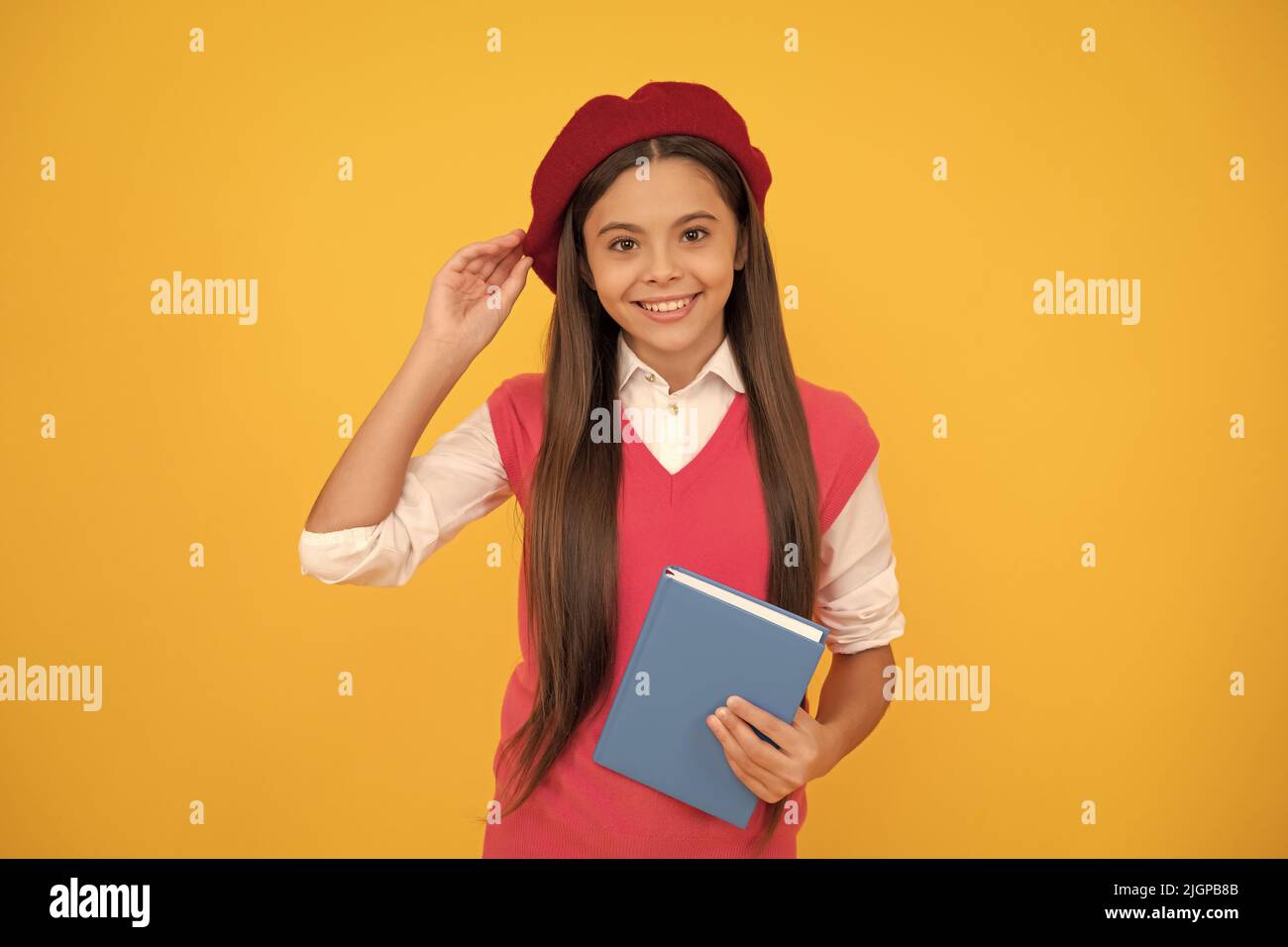 happy teen school girl in french beret hold copybook on yellow ...