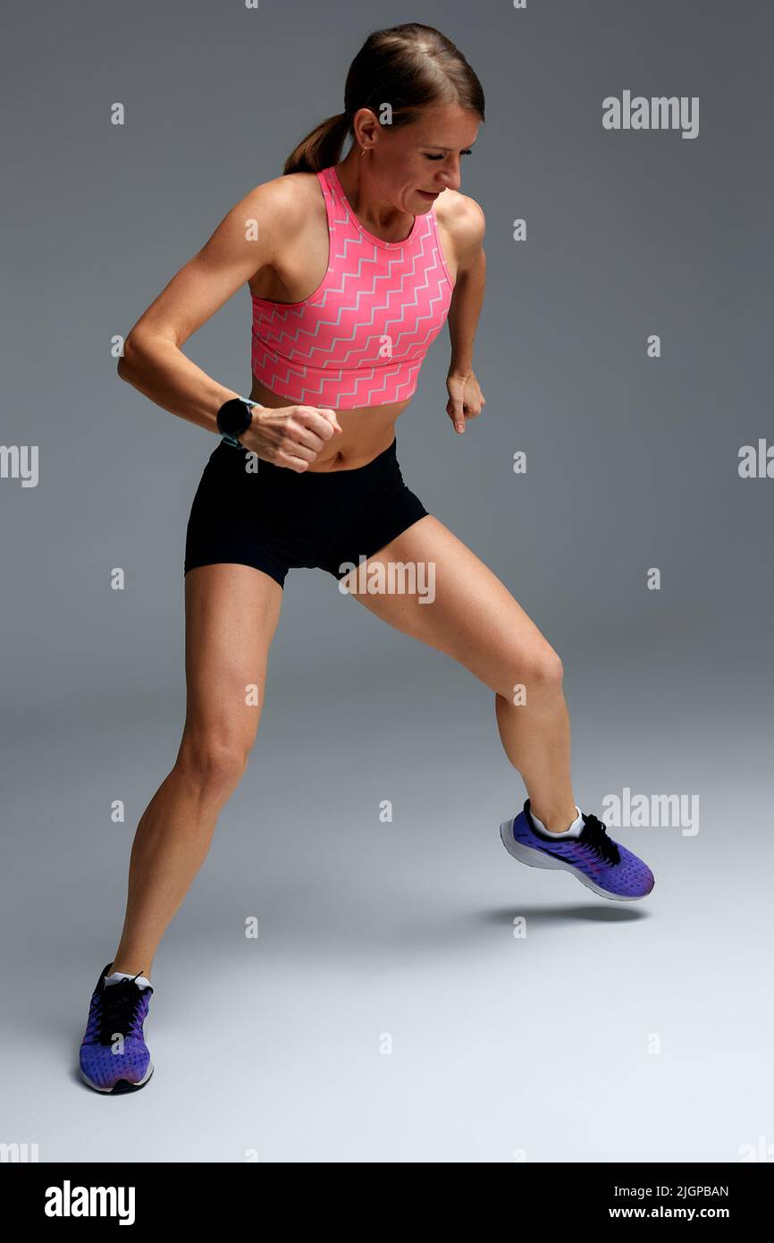 Determined muscular female athlete workout, raising leg and doing ...