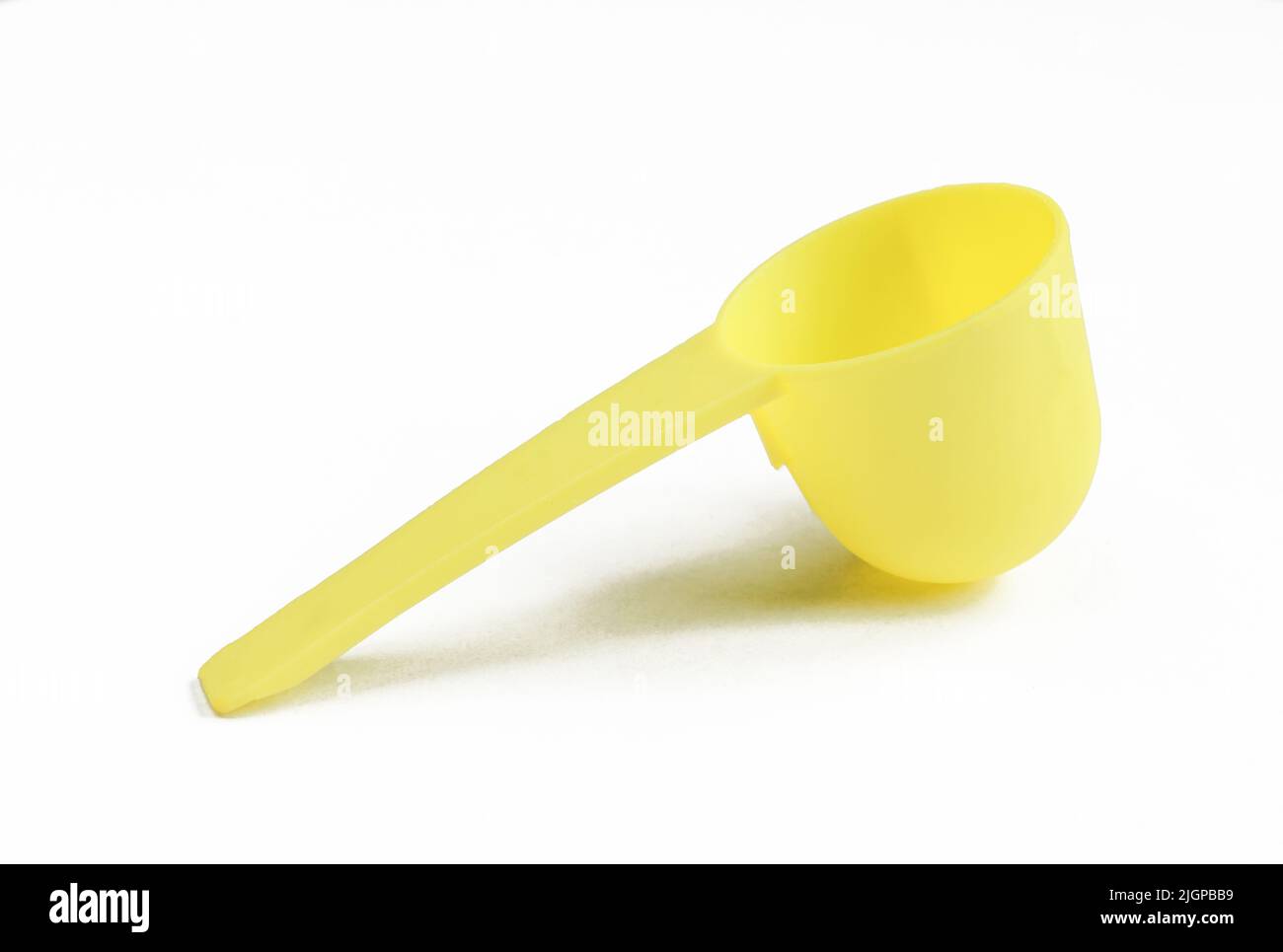 Empty measuring spoon isolated on white background. Deep yellow ...
