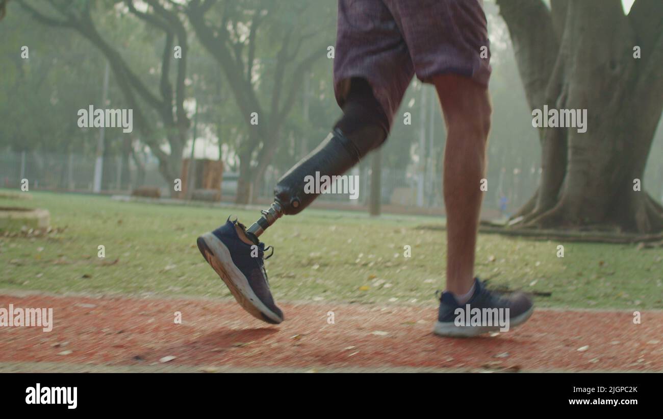 Disabled Athlete running with prosthetic leg at running track ...