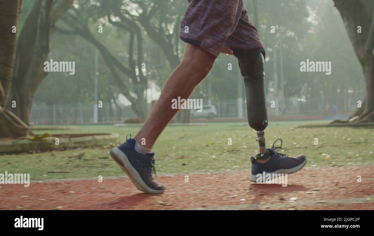 Disabled Athlete running with prosthetic leg at running track ...