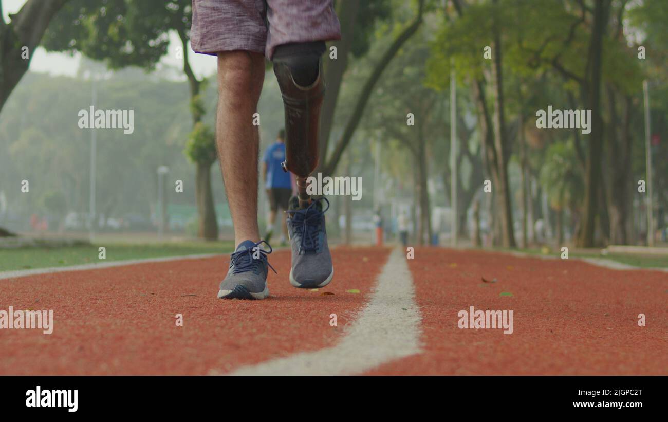 Disabled Athlete walking forward with prosthetic leg at running track ...