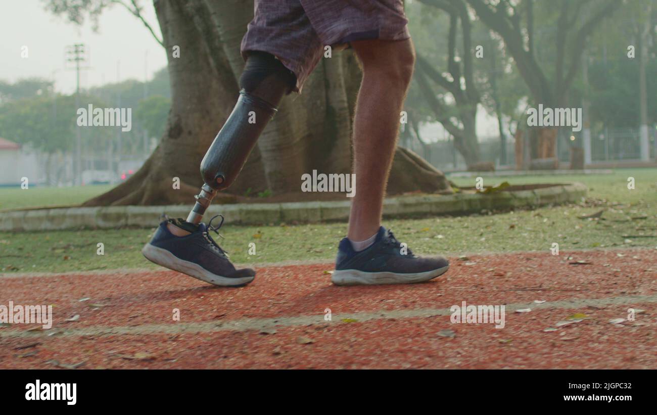 Disabled Athlete running with prosthetic leg at running track ...