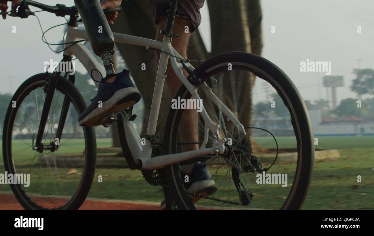 Athletic disabled man with prosthetic leg riding bicycle outside Stock ...