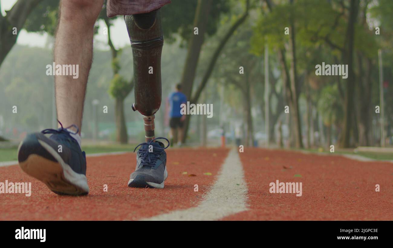 Disabled Athlete walking forward with prosthetic leg at running track ...