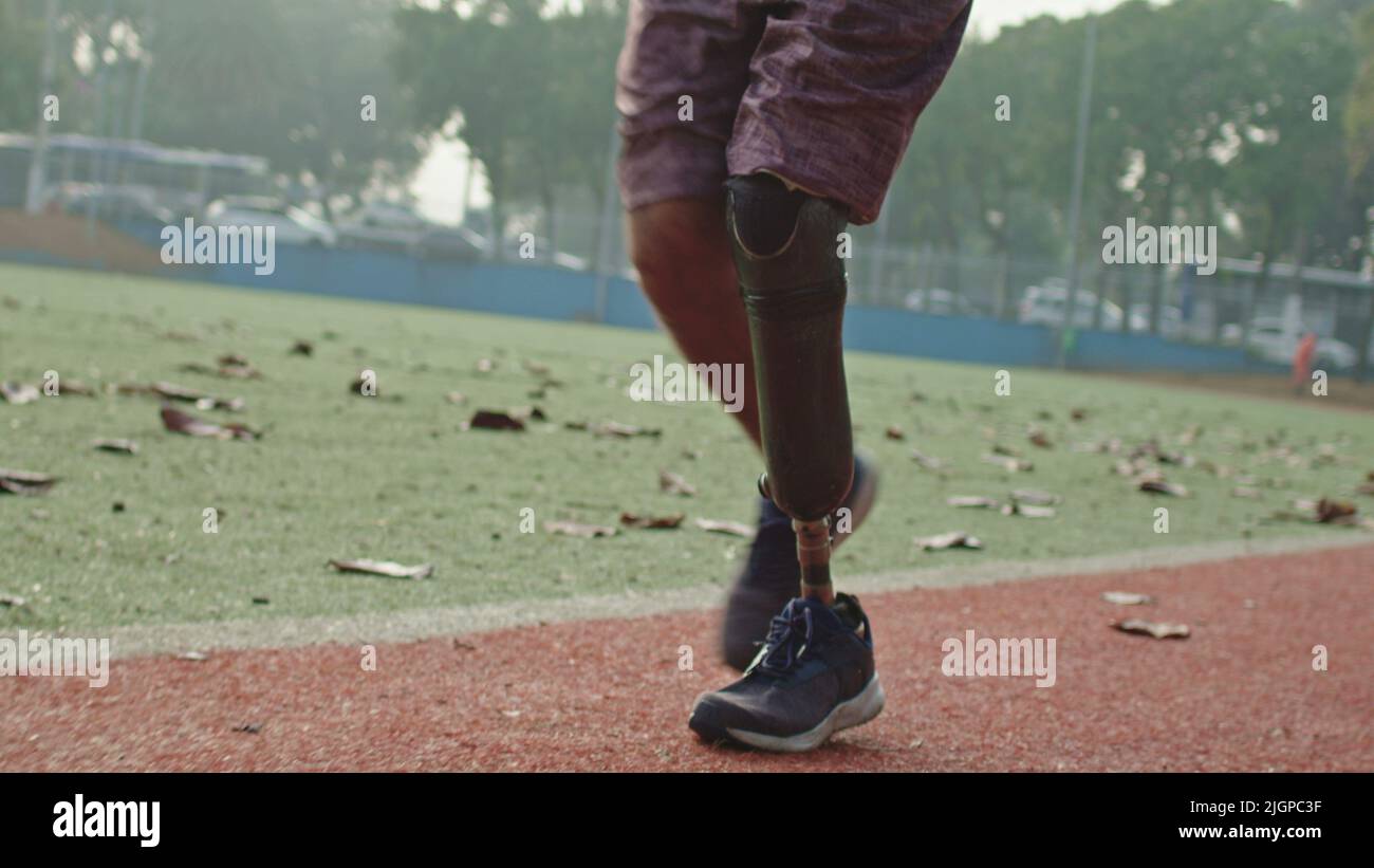 Disabled Athlete running with prosthetic leg at running track ...