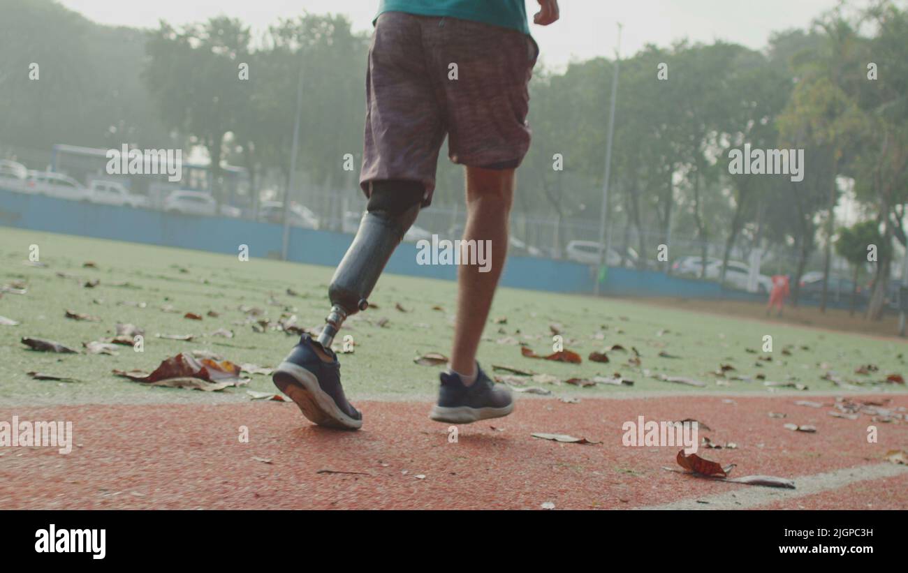 Disabled Athlete running with prosthetic leg at running track ...