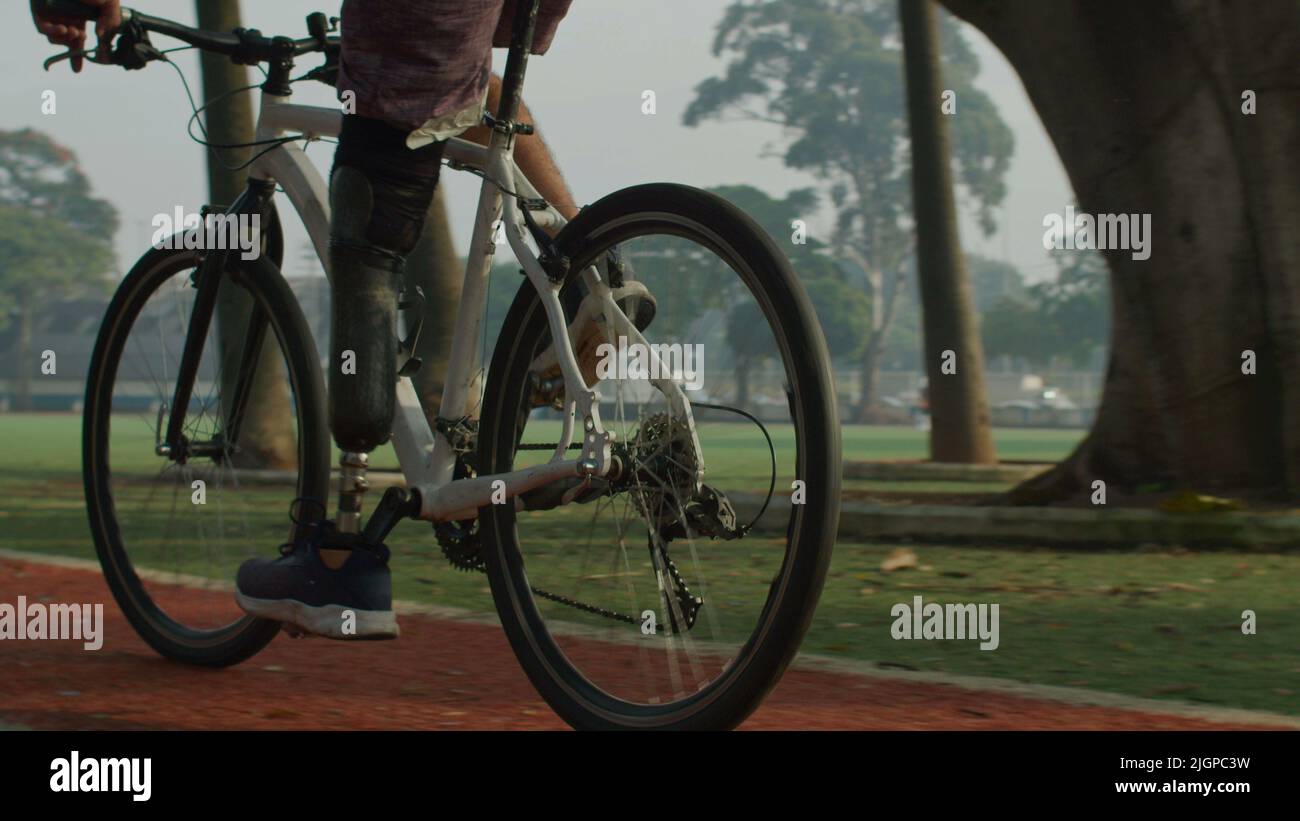 Athletic disabled man with prosthetic leg riding bicycle outside Stock ...