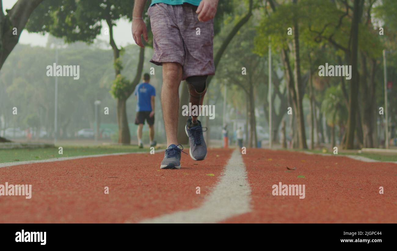 Disabled Athlete walking forward with prosthetic leg at running track ...