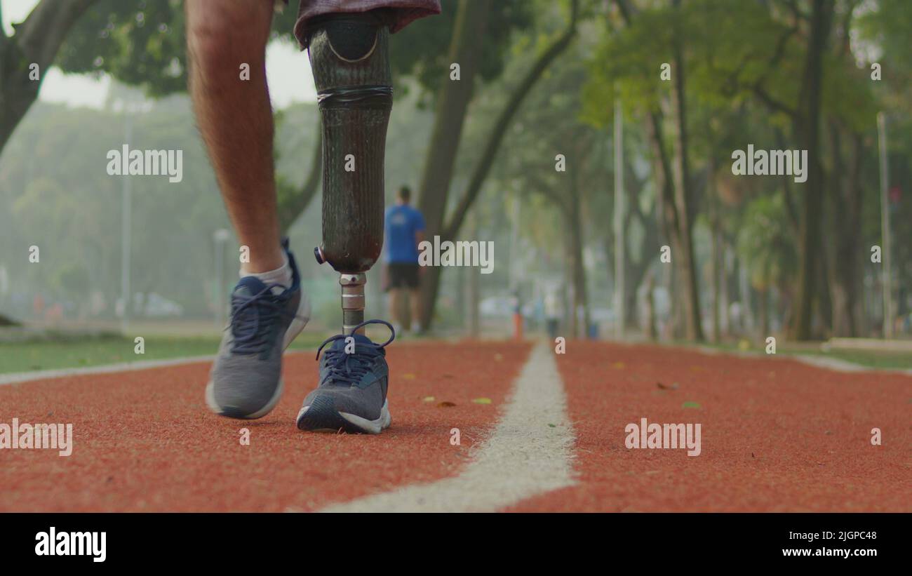 Disabled Athlete walking forward with prosthetic leg at running track ...