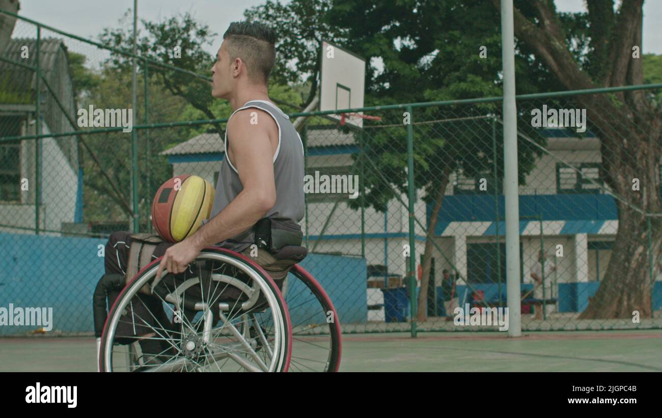 One paraplegic basketball player on wheelchair at basketball court ...