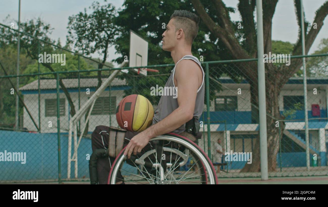 One paraplegic basketball player on wheelchair at basketball court ...