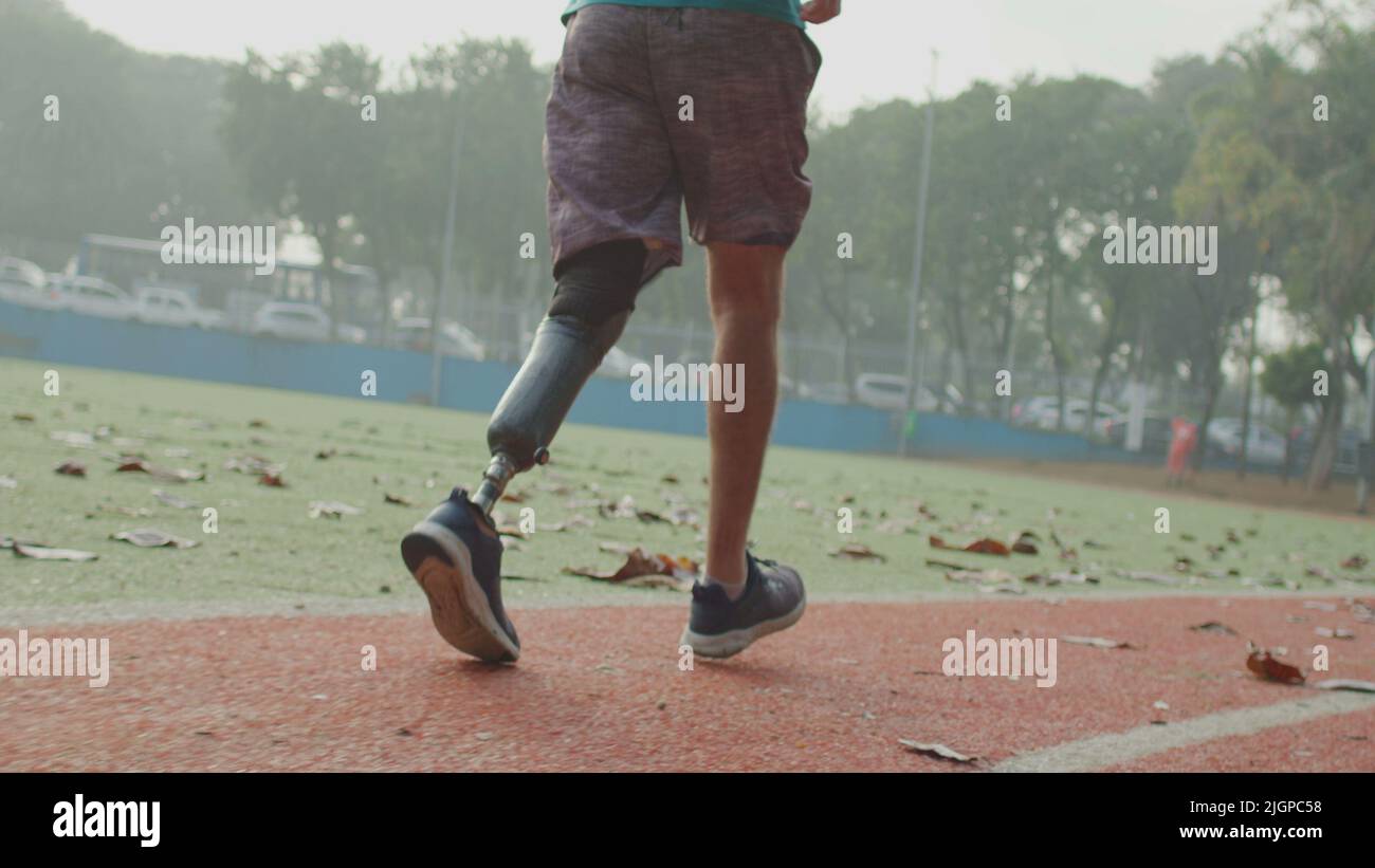 Disabled Athlete running with prosthetic leg at running track ...