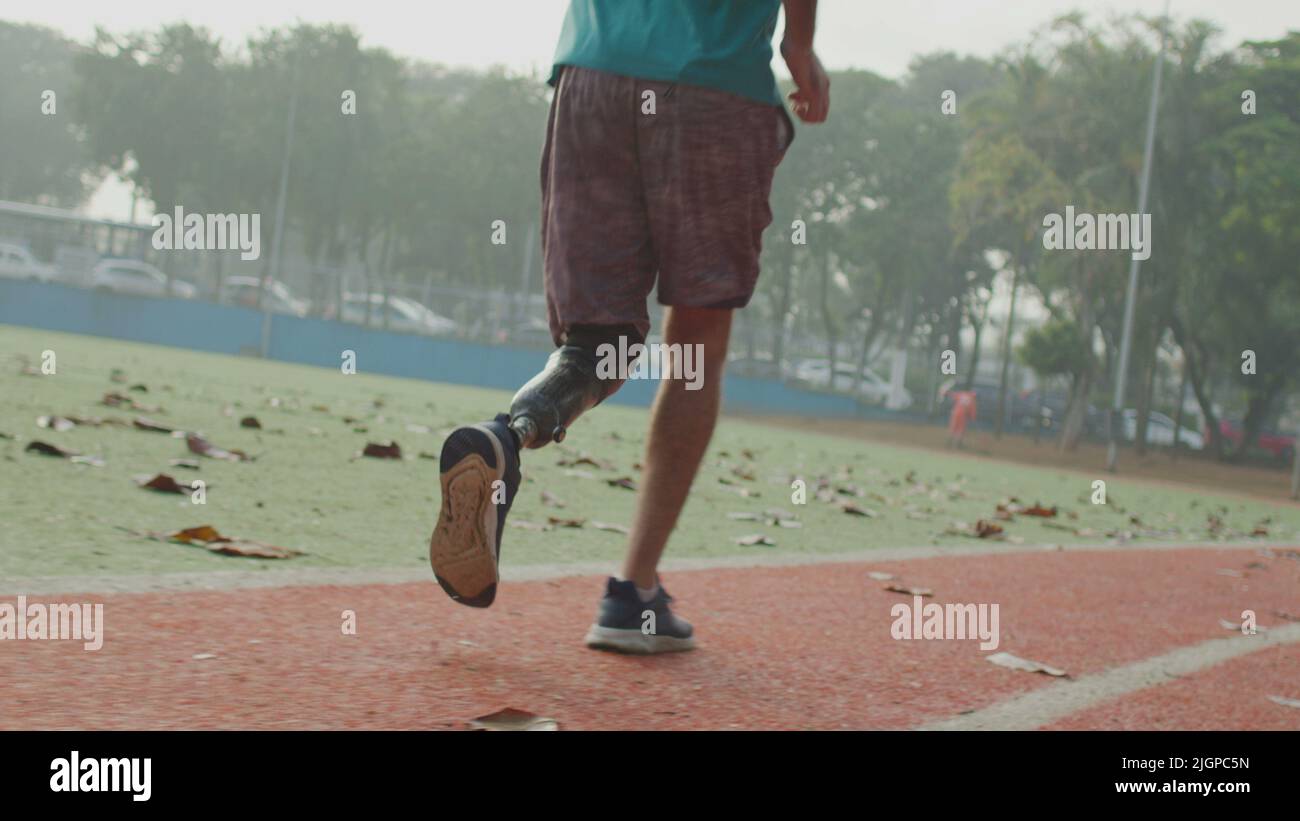 Disabled Athlete running with prosthetic leg at running track ...