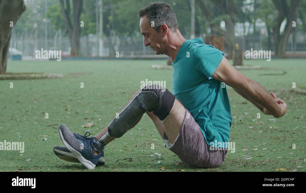 Athletic disabled person with prosthetic leg stretching at park Stock ...