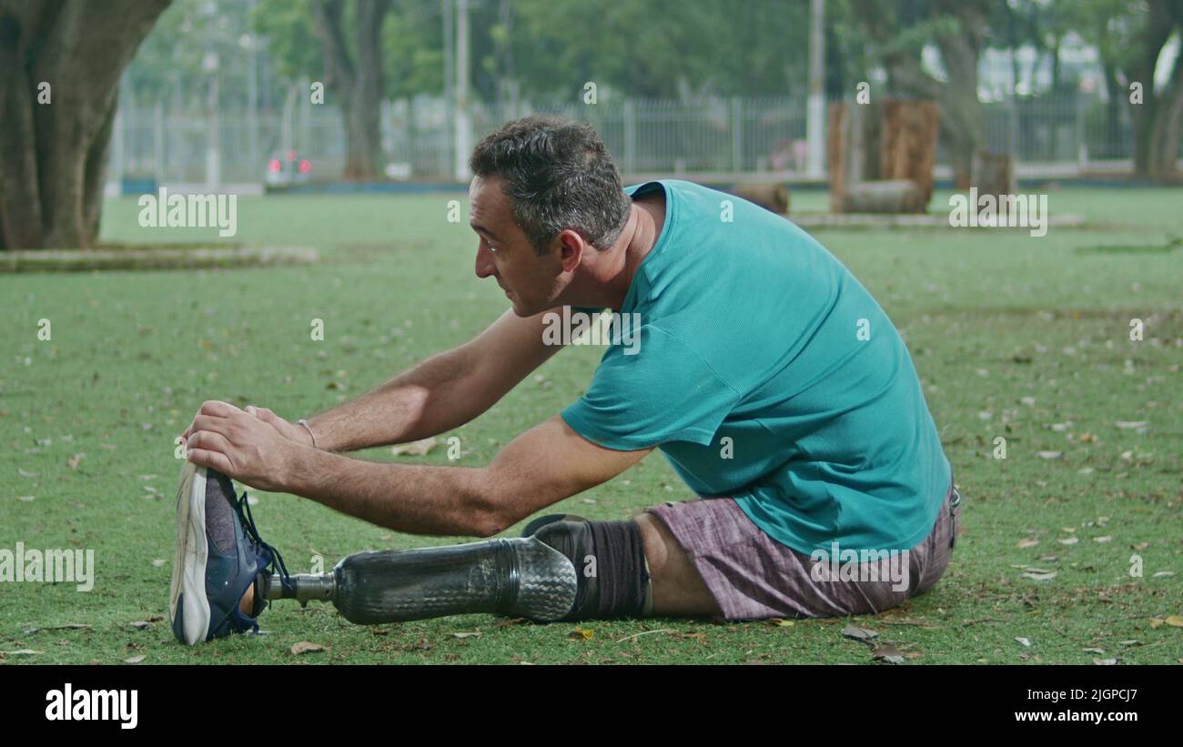 Athletic disabled person with prosthetic leg stretching at park Stock ...