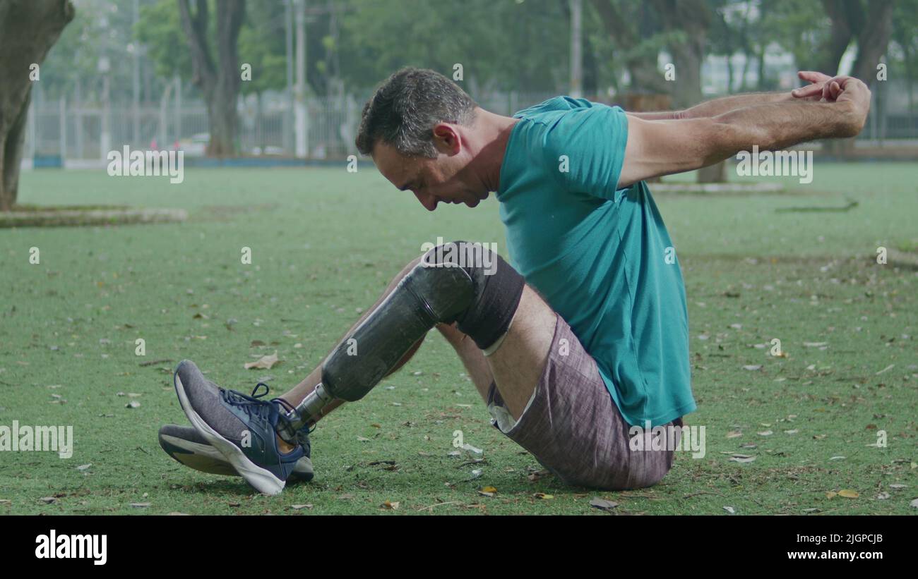 Athletic disabled person with prosthetic leg stretching at park Stock ...