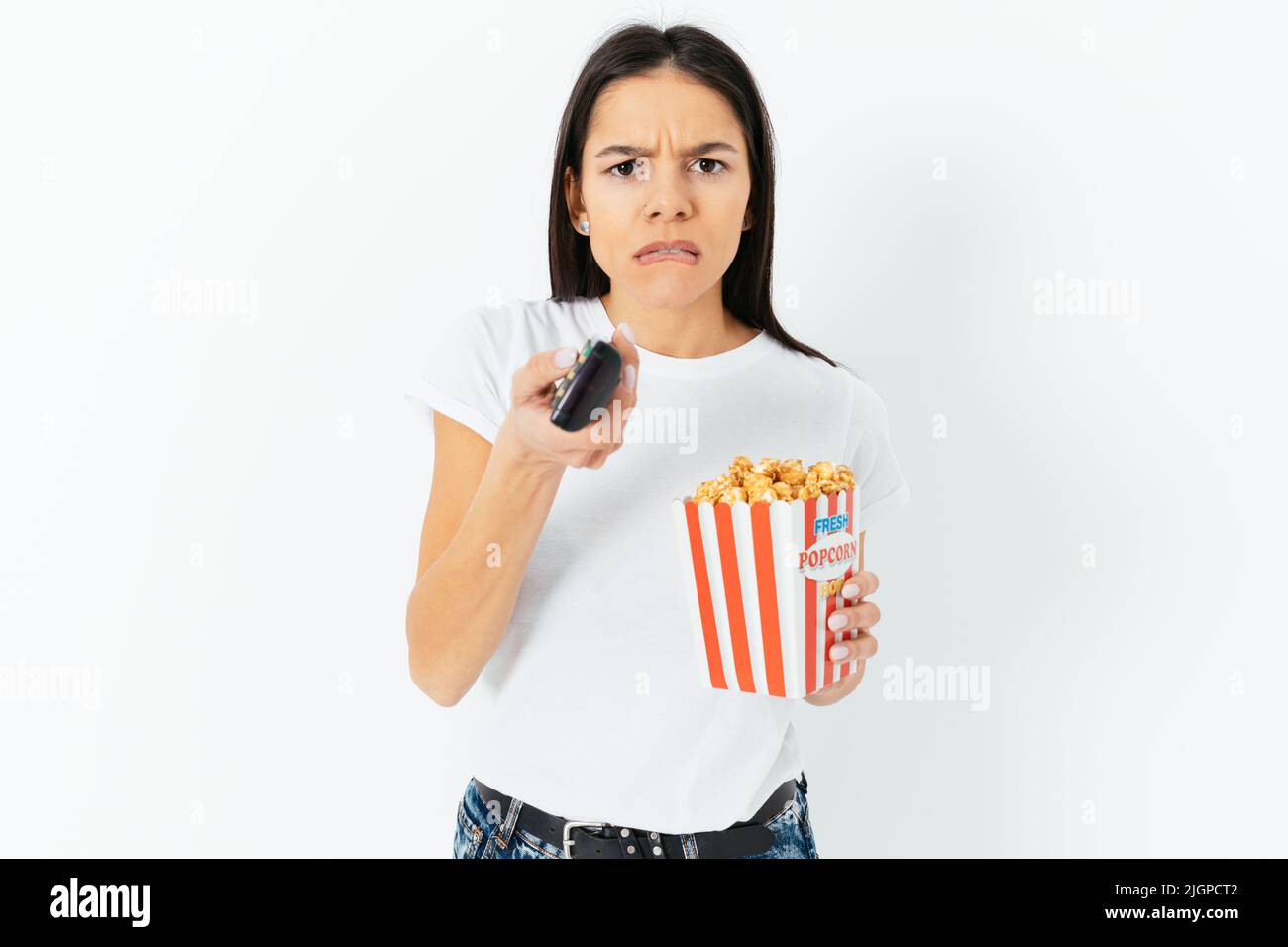 Upset confused young woman watching TV holding popcorn, changing ...
