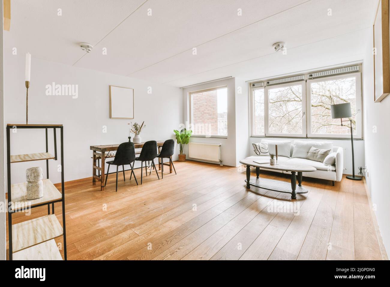 Comfortable chairs with cushions and sofa located near table under ...