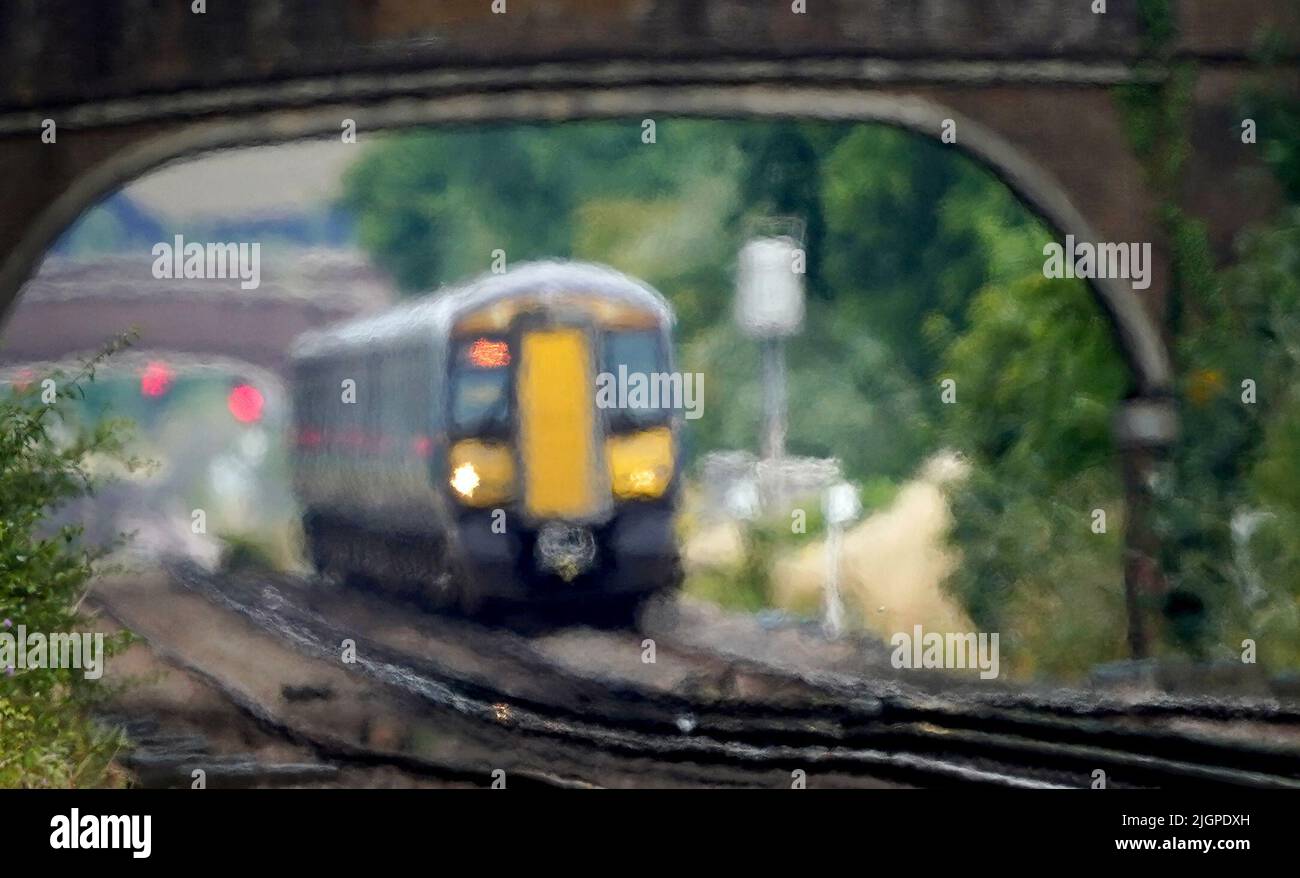 A train passes through heat haze on a railway line near Ashford in Kent ...