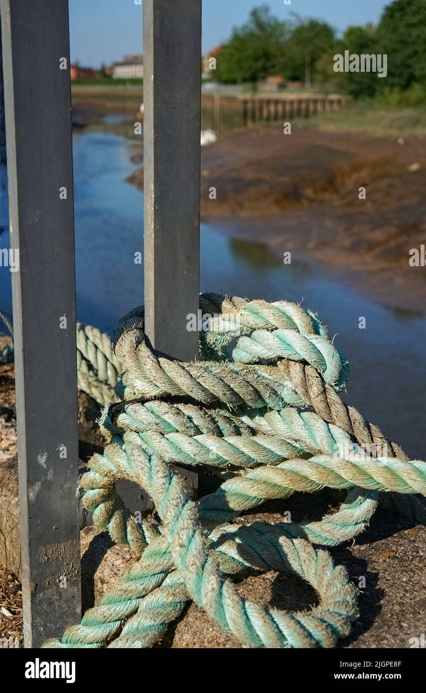 Close up of boat mooring rope on the riverside with soft focus river ...