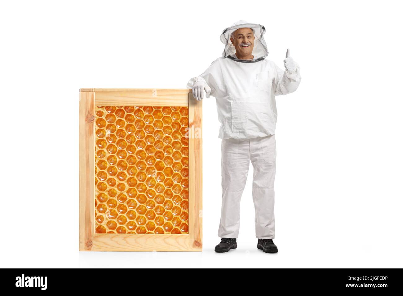 Mature male bee keeper in a uniform leaning on a big honeycomb frame ...