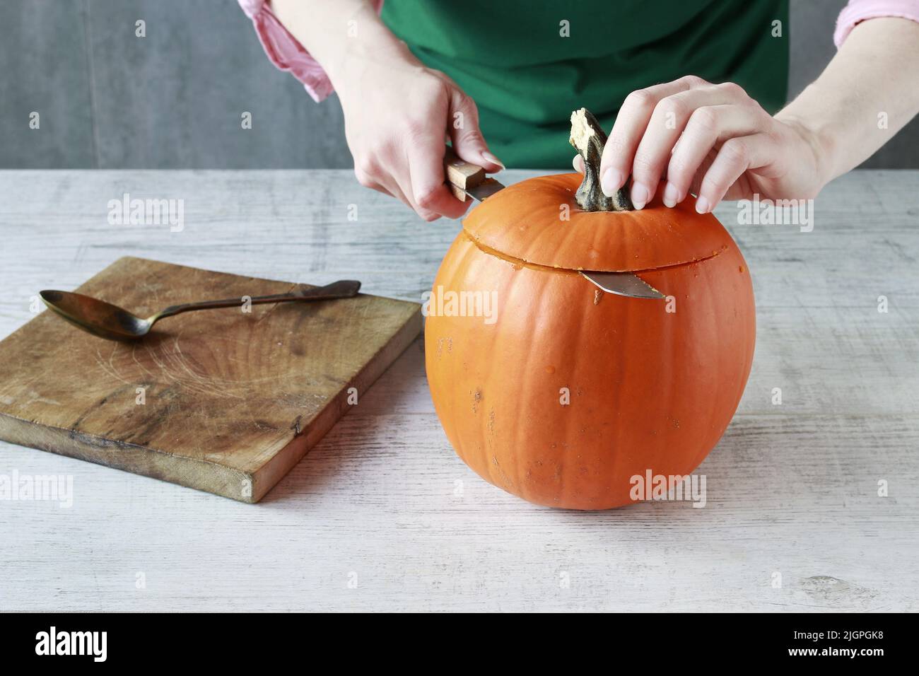 Florist at work: woman shows how to transform a pumpkin into a halloween lantern. Step by step ...