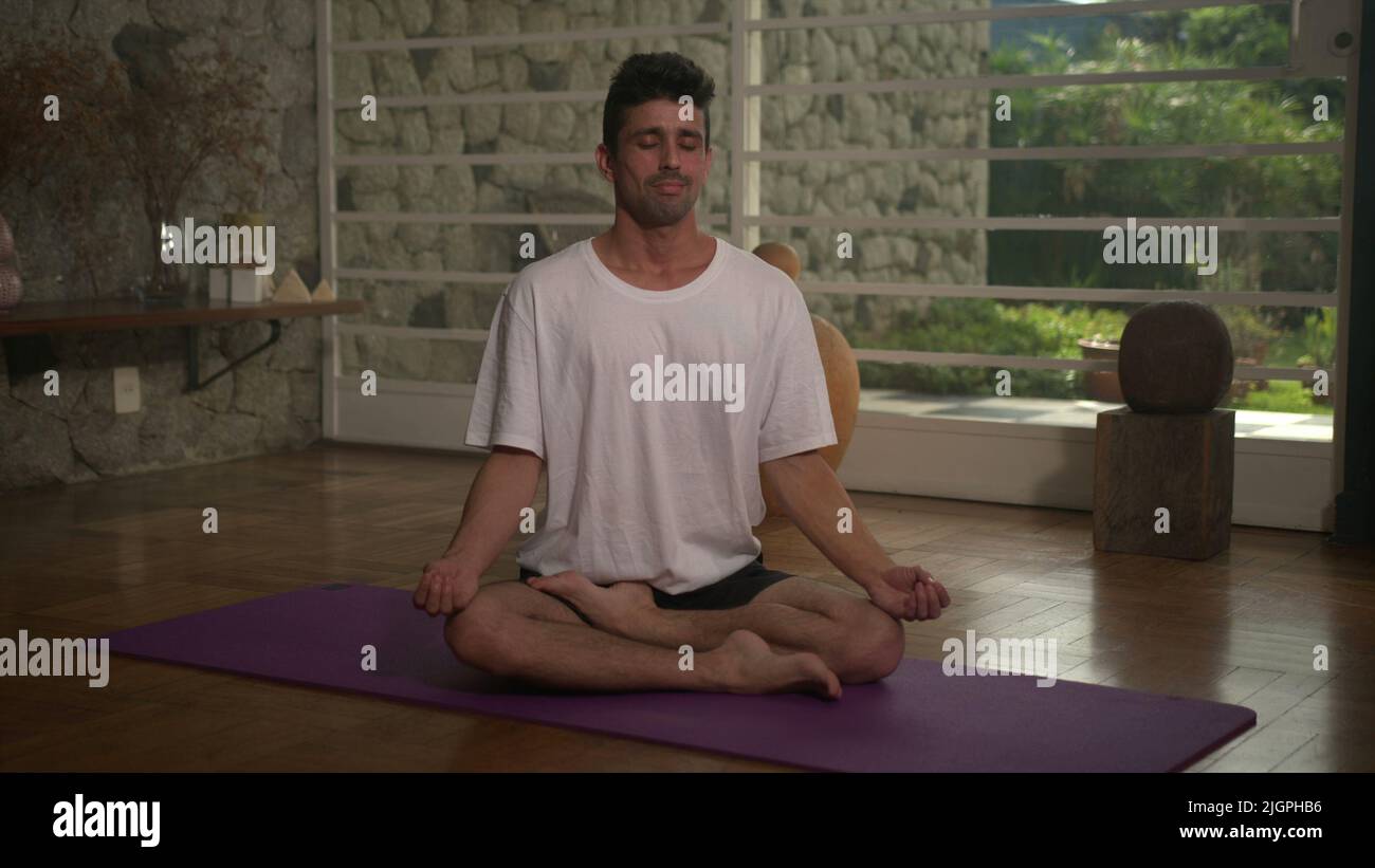 One mindful person practicing meditation sitting at home on his Yoga ...