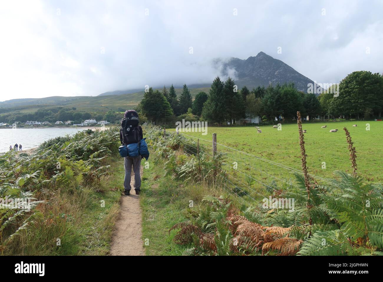 Solo Backpacker hiking with a big backpack. Arran Coastal Way. Isle of ...
