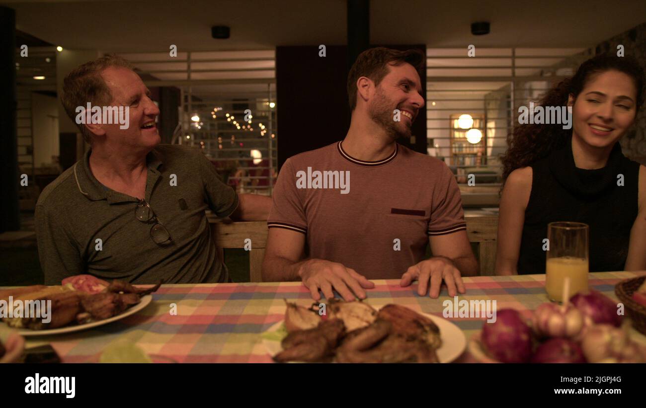 Man giving positive news to family during backyard dinner. Group of ...