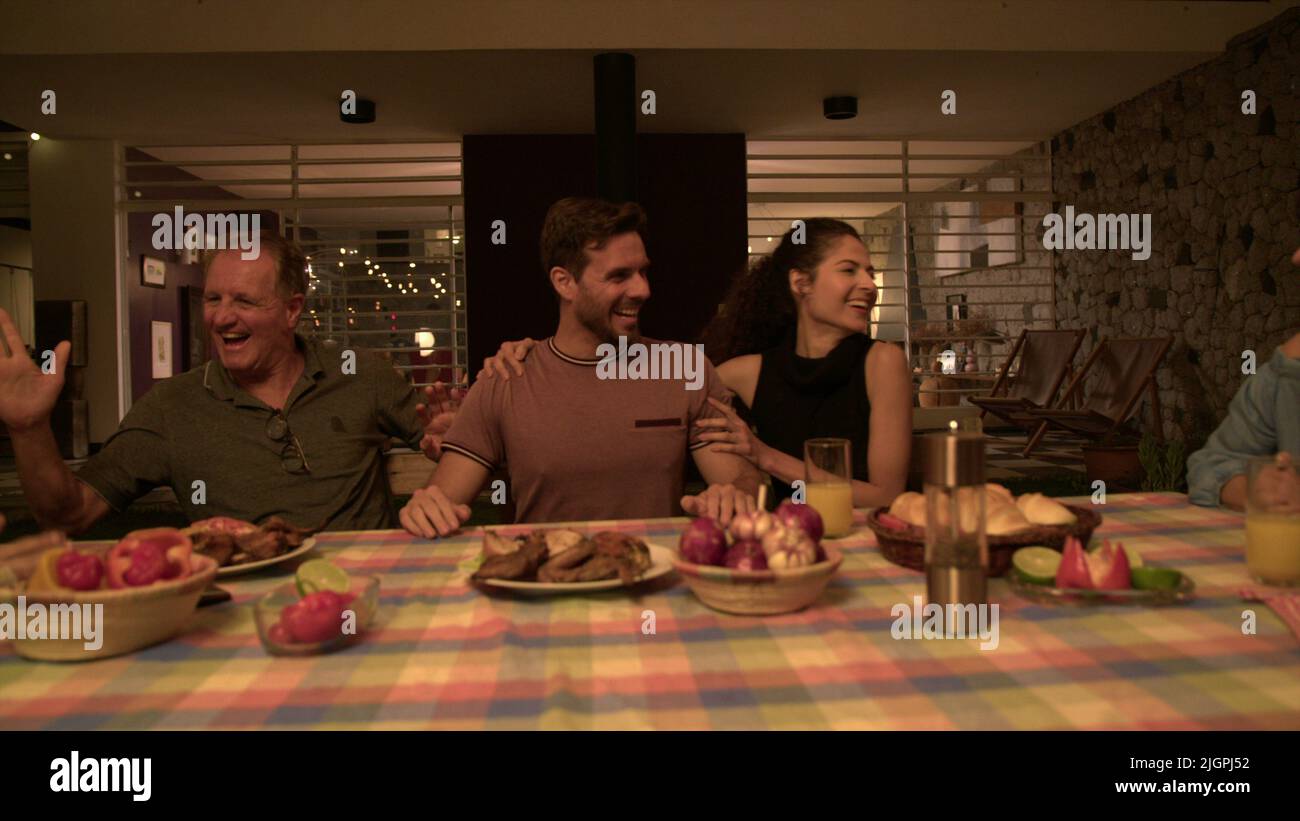 Man giving positive news to family during backyard dinner. Group of ...