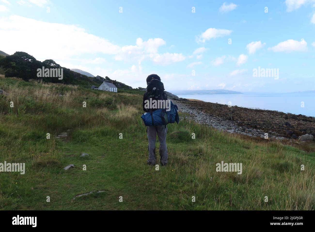 Solo Backpacker hiking with a big backpack. Arran Coastal Way. Isle of ...
