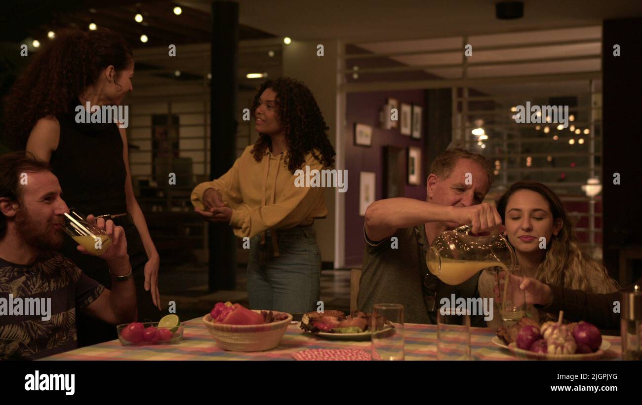 Family and friends at night together around table in backyard in ...
