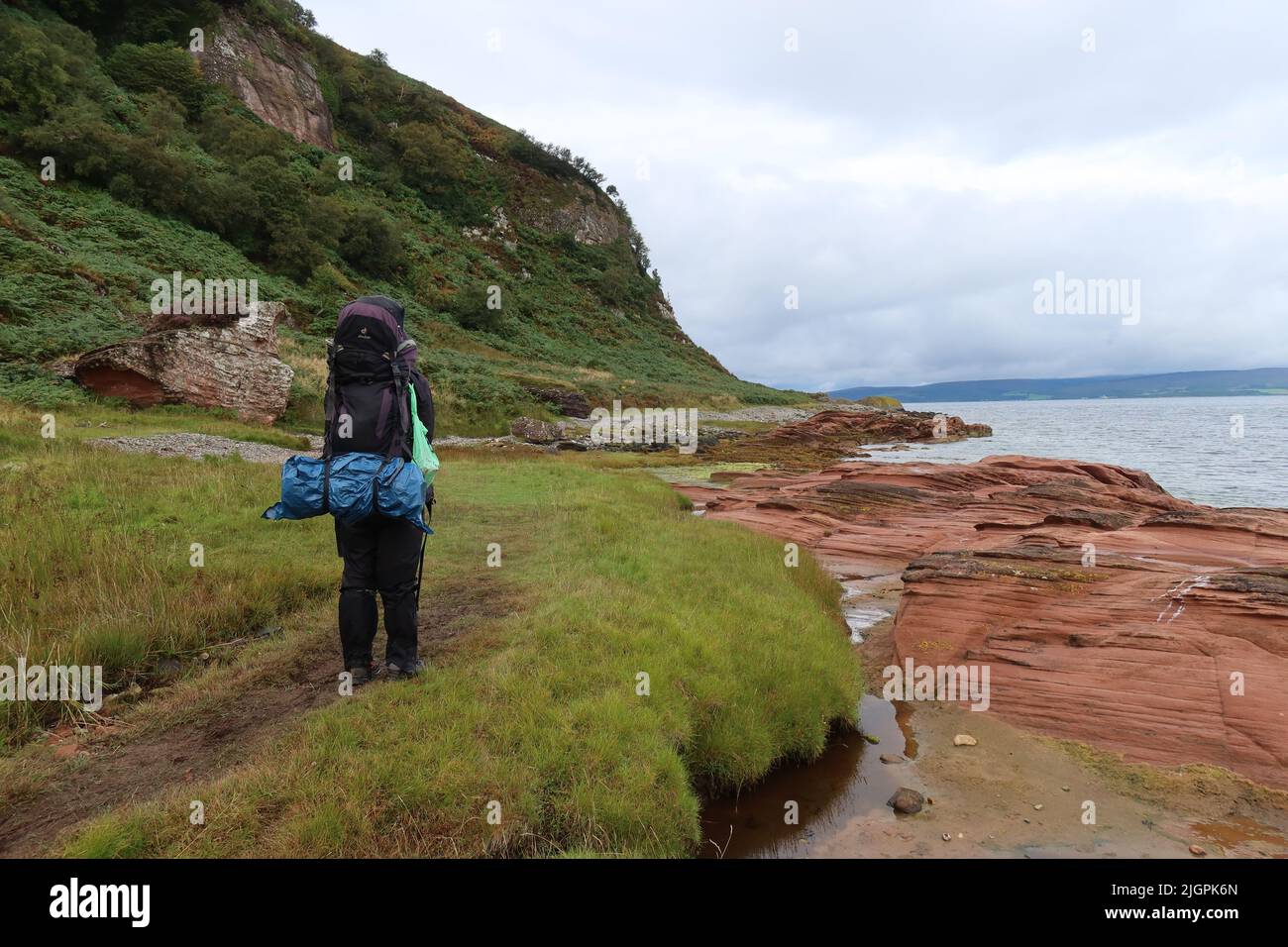 Solo Backpacker hiking with a big backpack. Arran Coastal Way. Isle of ...
