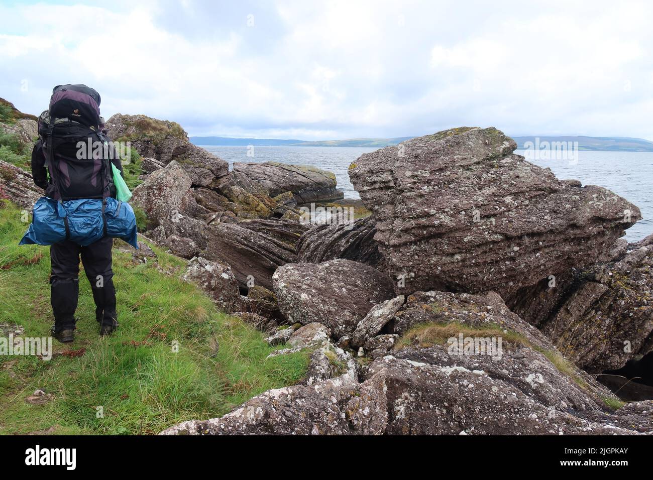 Solo Backpacker hiking with a big backpack. Arran Coastal Way. Isle of ...