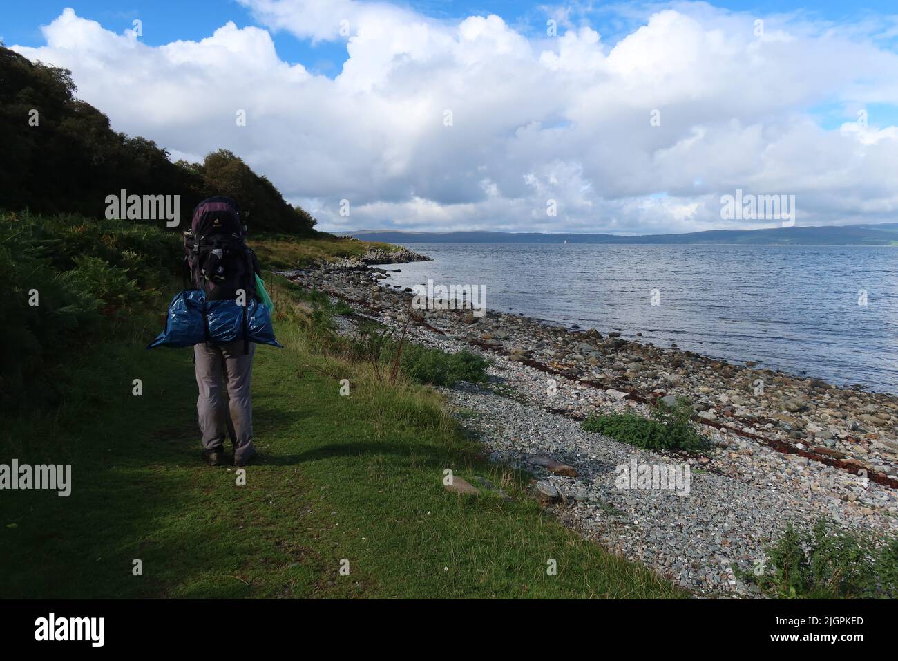 Solo Backpacker hiking with a big backpack. Arran Coastal Way. Isle of ...