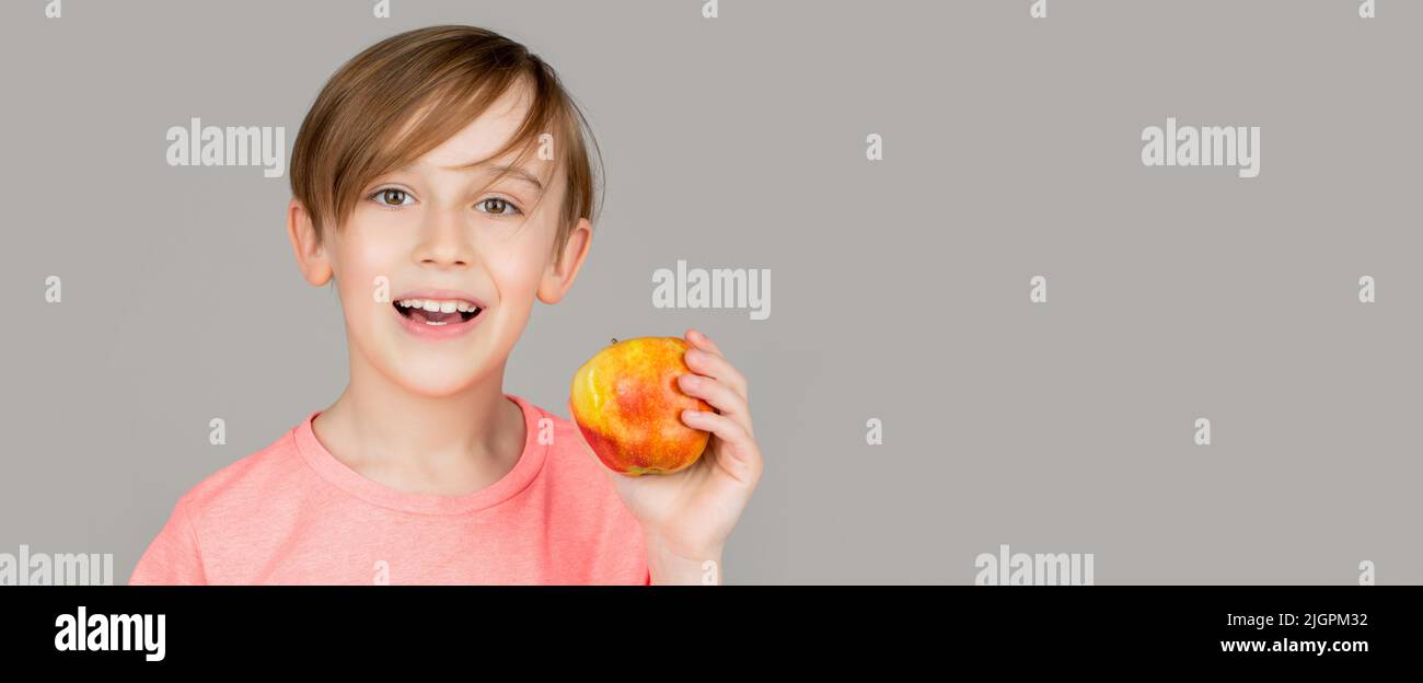 Baby boy eating apple and smiling. Boy smiles and has healthy white ...