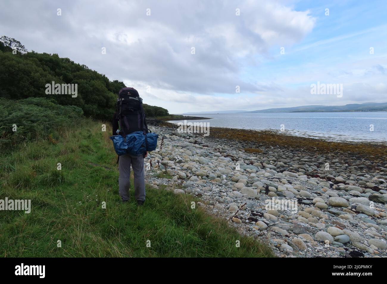 Solo Backpacker hiking with a big backpack. Arran Coastal Way. Isle of ...