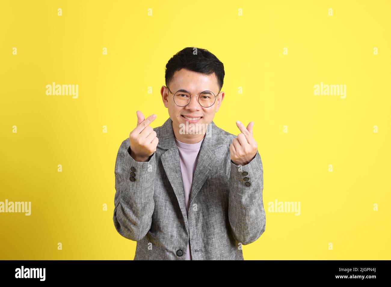 The Asian LGBTQ man with grey blazer standing on the yellow background ...
