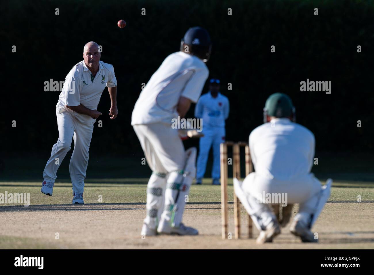 Bowler delivering cricket ball Stock Photo - Alamy