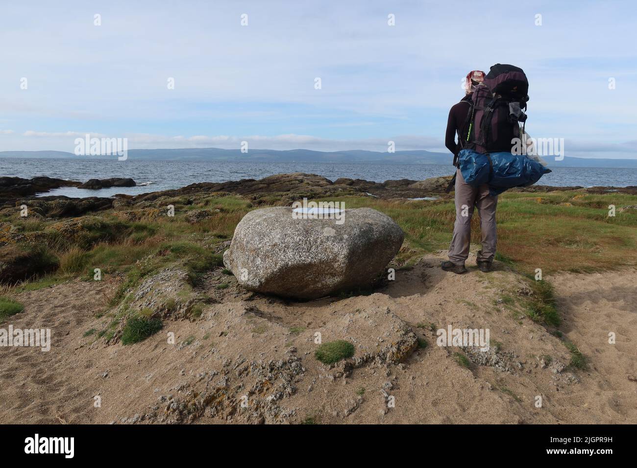 Solo Backpacker hiking with a big backpack. Arran Coastal Way. Isle of ...
