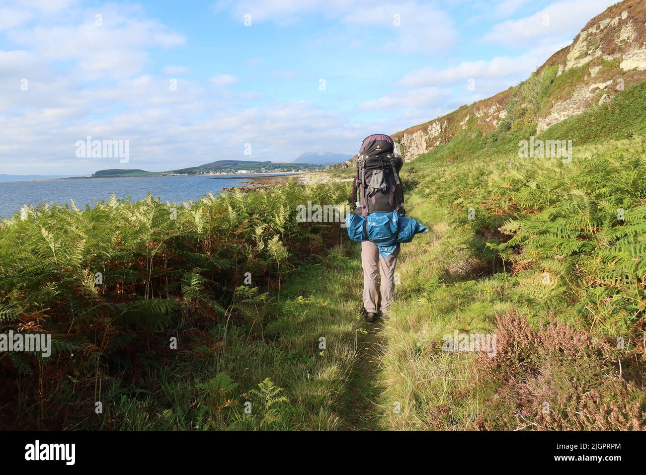 Solo Backpacker hiking with a big backpack. Arran Coastal Way. Isle of ...