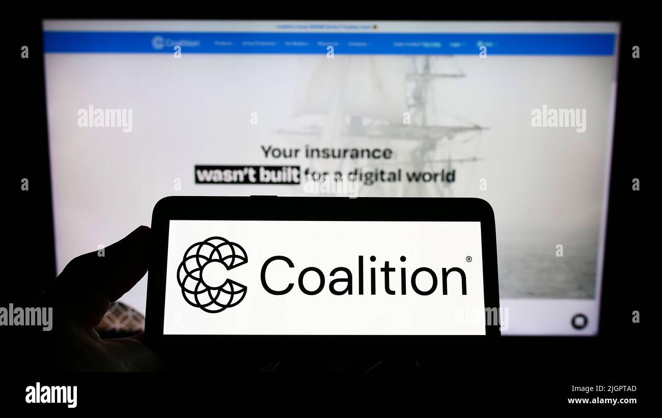 Person holding smartphone with logo of US cyber insurance company ...