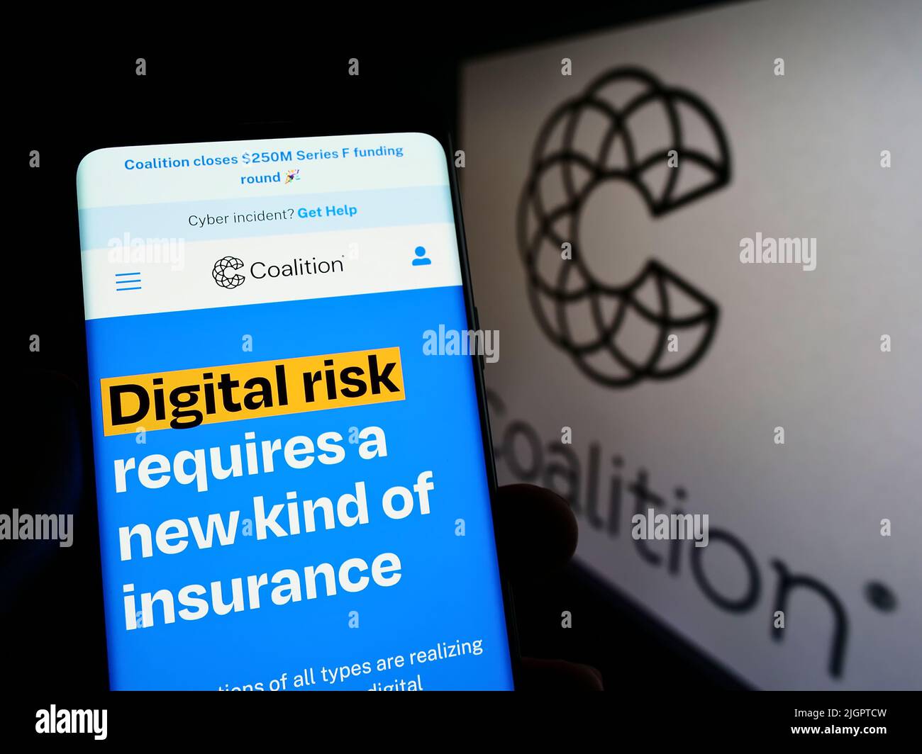 Person holding cellphone with website of US cyber insurance company ...