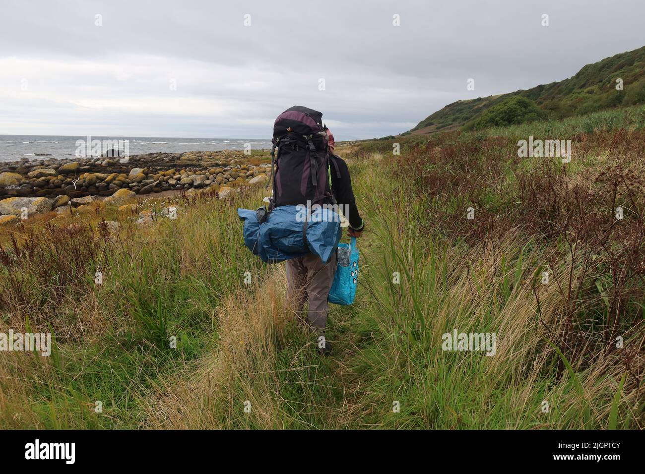 Solo Backpacker hiking with a big backpack. Arran Coastal Way. Isle of ...