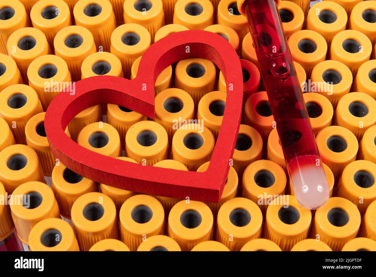 heart shape over blood collection tubes, representing coronary problems ...