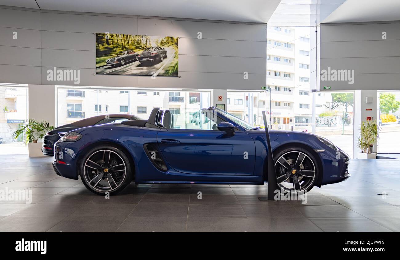 A picture of a dark blue Porsche 718 Boxster inside a dealership Stock ...