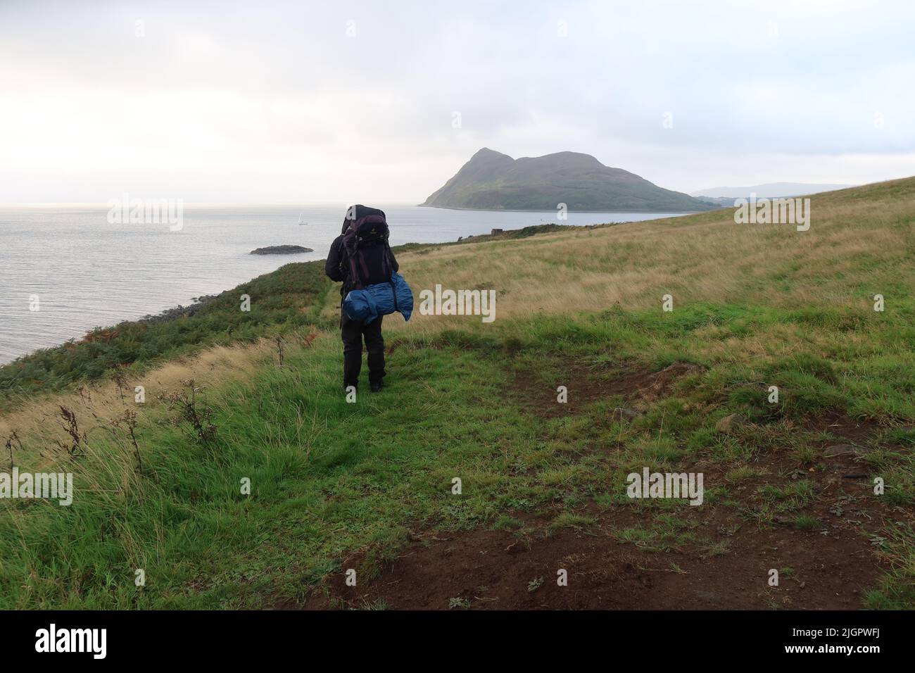 Solo Backpacker hiking with a big backpack. Arran Coastal Way. Isle of ...